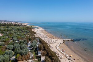 Uma praia privada, espreguiçadeiras, guarda-sóis de praia 