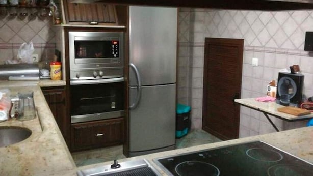 Cozinha compacta com forno embutido, micro-ondas e frigorífico.