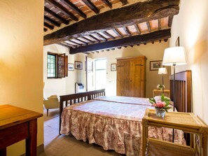 Quarto com cama, móveis de madeira, guarda-roupa e abajur.