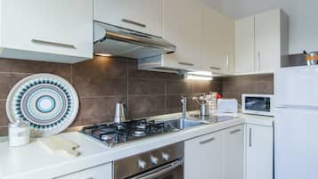 Apartamento, 1 quarto | Cozinha privada | Geladeira grande, micro-ondas, fogão, cooktop