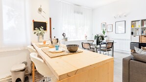 Uma cozinha moderna com ilha de madeira, cadeiras brancas e uma mesa de jantar.