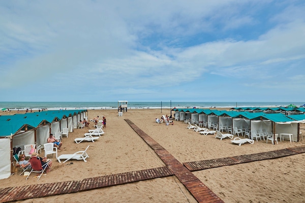 Uma praia privada, espreguiçadeiras, guarda-sóis de praia
