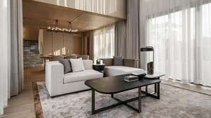 Uma sala de estar moderna com sofá, mesa de centro e área de jantar ao fundo.