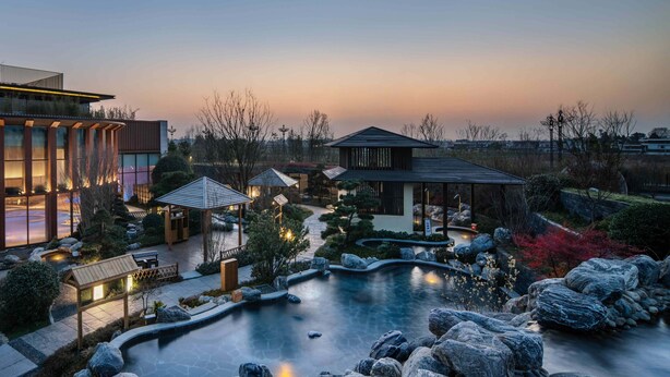 Um resort com uma piscina grande, formações rochosas e edifícios em estilo tradicional.