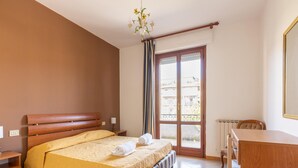 Quarto com cama, escrivaninha, cadeira e cômoda.