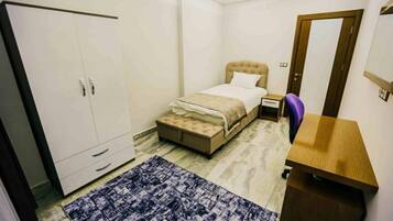 Quarto com cama, guarda-roupa, escrivaninha e cadeira.