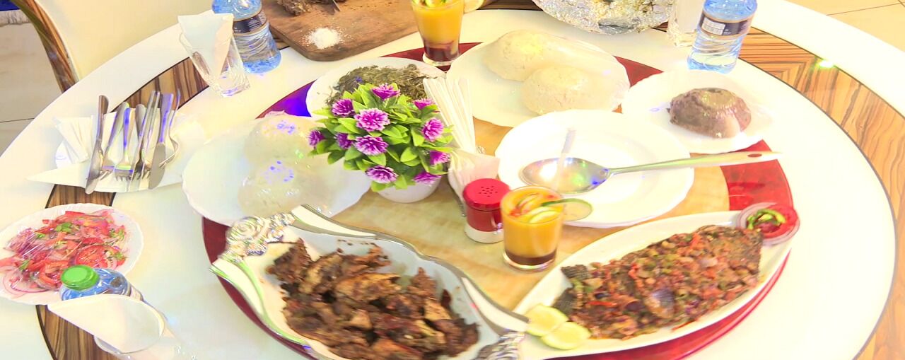 Uma mesa posta com diversos pratos, utensílios e uma garrafa de água.