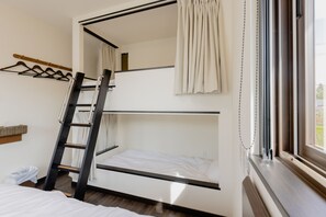 Quarto com beliche, escada, janela com cortinas e prateleira de madeira com cesta.