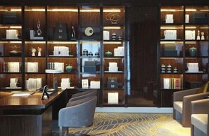 Uma biblioteca moderna com estantes, uma mesa e assentos confortáveis.