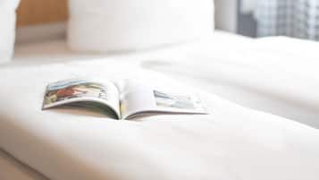 Cama bem arrumada com um livro aberto sobre ela.