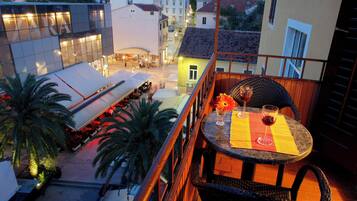 Terraço no telhado com uma mesa, cadeiras e vista para a cidade.