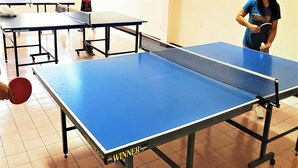 Uma mesa de tênis de mesa com superfície azul e uma rede.