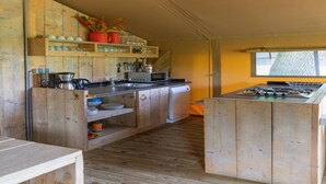 Cozinha com armários de madeira, pia, fogão e janela.