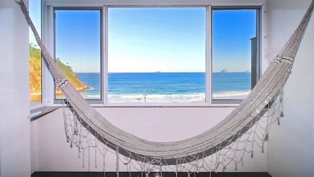 Uma rede presa a uma janela com vista para o oceano.