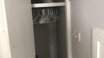 Um armário com cabideiro e porta.