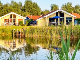 Uma fileira de casas com um lago ao primeiro plano.