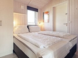 Quarto com duas camas, uma janela e uma porta.