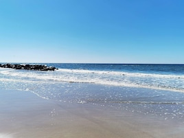 Uma praia com céu limpo e ondas calmas.
