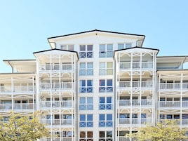 Um hotel com vários andares, varandas e grandes janelas.