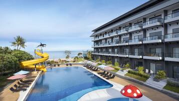 Um hotel moderno com uma piscina grande, um toboágua e vista para o oceano.