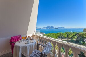 Varanda com mesa posta para o pequeno-almoço, com vista para a paisagem costeira.