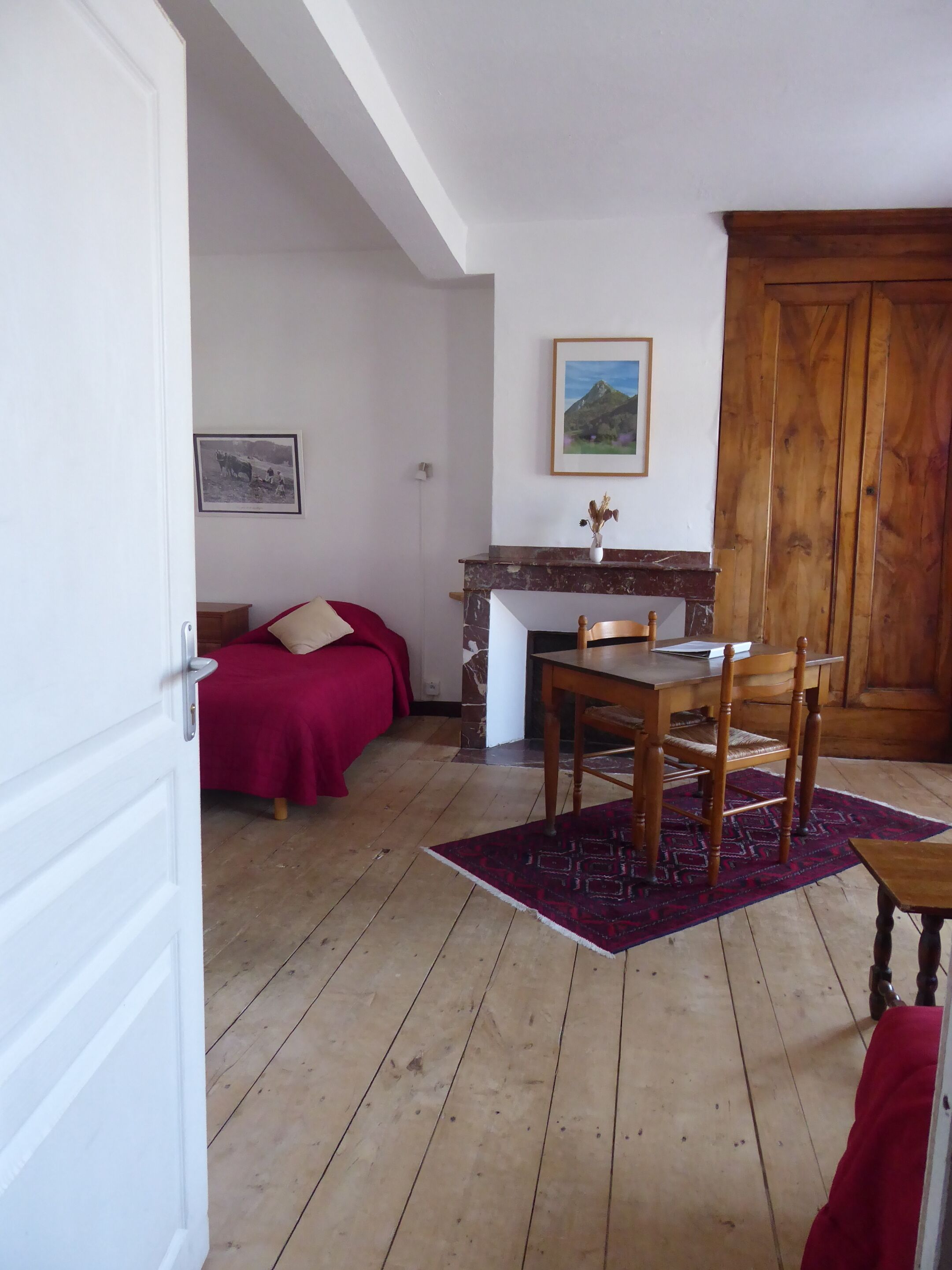Um quarto com uma cama, uma escrivaninha e uma mesa de jantar.