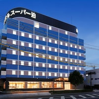 Hotel de vários andares com fachada moderna, apresentando uma sinalização chamativa no topo.