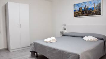 Quarto com cama, guarda-roupa e um quadro na parede.