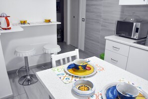 Uma placa de cozinha, uma cafeteira/bule, uma chaleira elétrica 
