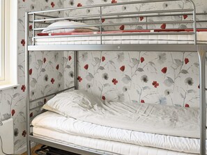 Uma cama box com papel de parede estampado com flores.
