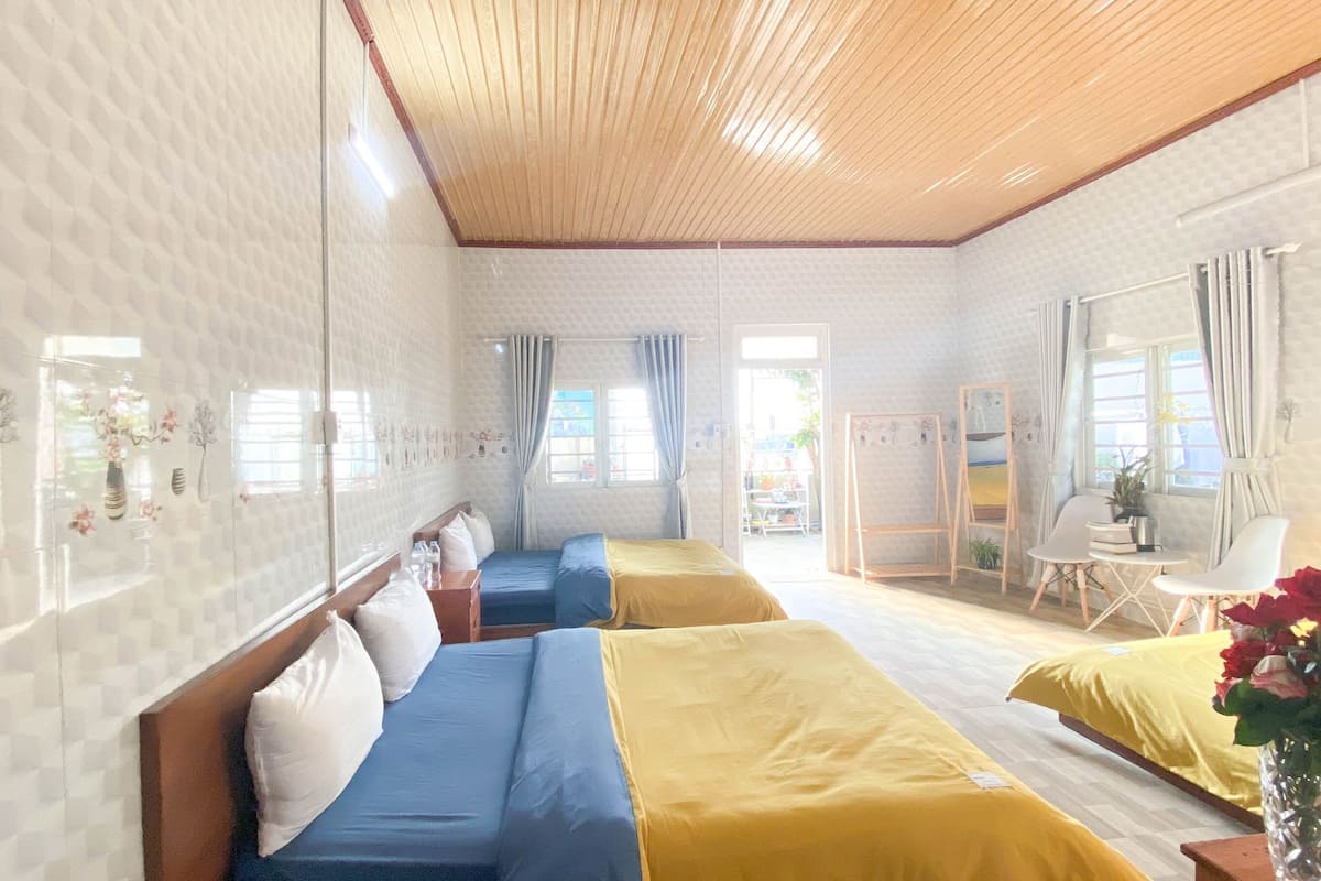 Quarto de hotel com duas camas, teto de madeira e vista para o exterior.