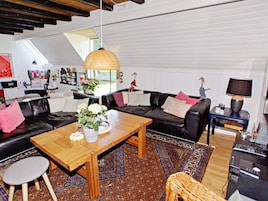 Uma sala de estar com sofá, mesa de centro e abajur.