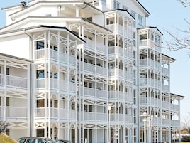 Um edifício de vários andares com varandas e grandes janelas.