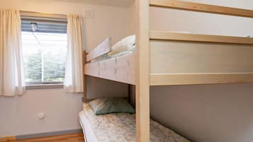 Quarto com beliche, janela, cortinas e piso de madeira.
