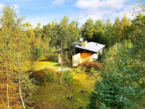 Uma casa moderna rodeada por uma floresta densa.