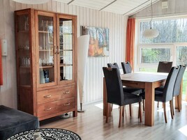 Uma sala de jantar com um armário de madeira, uma mesa e cadeiras.