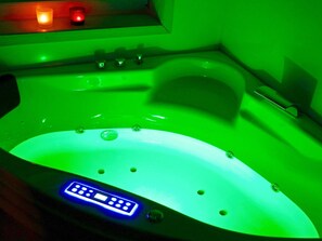 Uma banheira com painel de controle e iluminação verde.