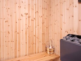 Uma sauna de madeira com um banco e uma cesta.
