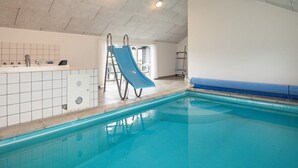 Piscina interna com escorregador, sala de trocas e área de chuveiros.