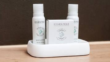 Uma bandeja branca com dois frascos de loção corporal ECO-BOUTIQUE e uma caixa, tudo com um logotipo verde.