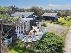 Um imóvel residencial com varanda, área de estar ao ar livre e vista para a paisagem circundante.