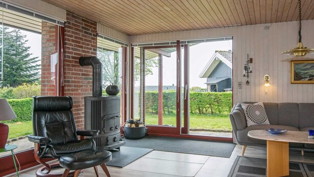 Uma sala de estar moderna com lareira, uma poltrona de couro, um sofá e uma mesa de jantar.