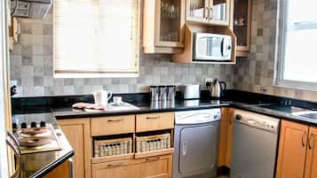 Apartamento, 2 quartos | Cozinha privada | Um frigorífico, um micro-ondas, um forno, uma placa de cozinha