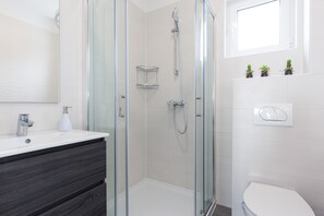 Apartamento Deluxe, vista para o mar | Casa de banho | Um polibã, toalhas fornecidas, sabão, papel higiénico 