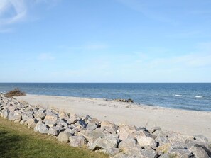 Uma praia com costa rochosa e mar calmo.
