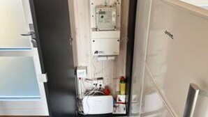 Quarto com cozinha compacta, incluindo micro-ondas, pequena geladeira e tomadas elétricas.