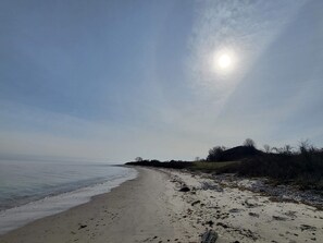 Uma praia com céu limpo e o sol brilhando.