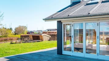 Uma casa moderna com uma grande porta de vidro que dá para um espaço de pátio.