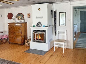 Quarto com lareira, móveis de madeira e uma cadeira branca.