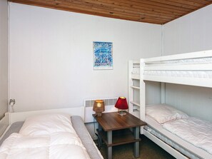 Quarto com duas camas, uma mesinha com abajur e um quadro na parede.